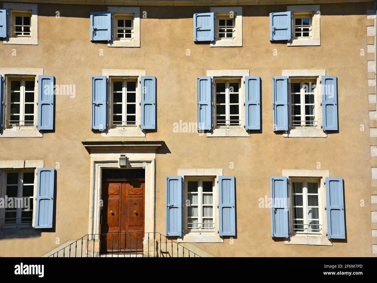Provençal style rural house facade with an ochre stucco wall and light ...