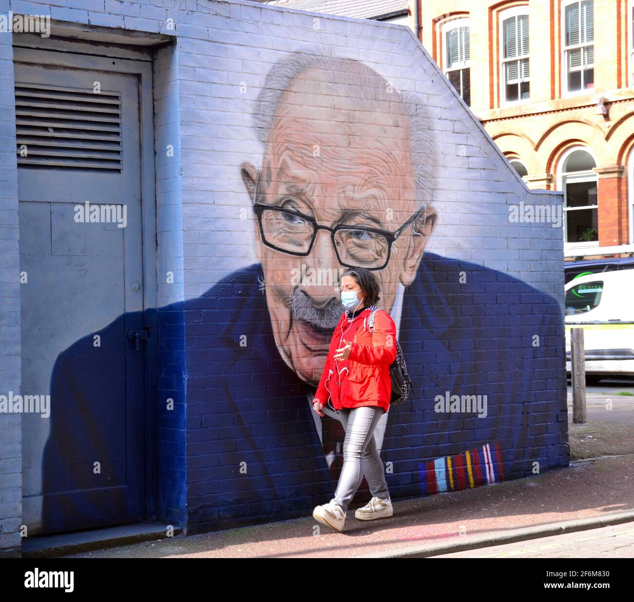 A woman walks in front of a newly created street art painting of ...