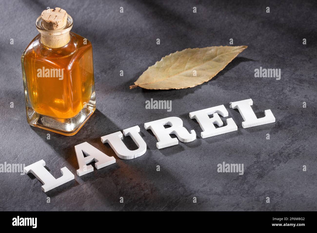 Organic laurel oil - Laurus nobilis. Laurel word in wooden letters ...
