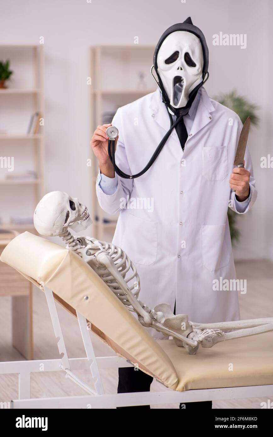 Devil doctor examining skeleton patient in the clinic Stock Photo - Alamy