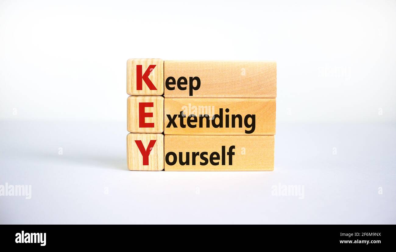 KEY, keep extending yourself symbol. Wooden blocks with words 'KEY ...