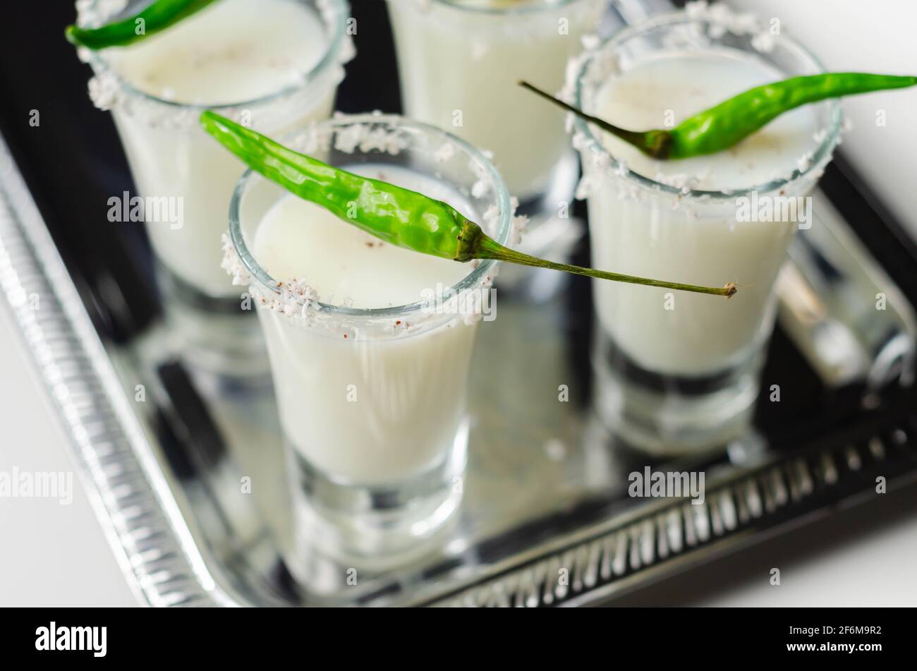 Coconut cocktail in drink shot glass decorated with coconut flakes and ...
