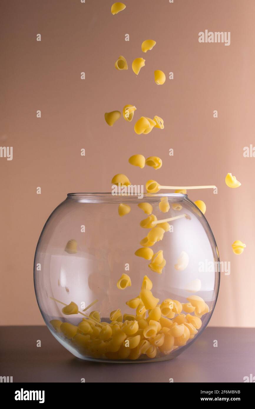 pasta falling in a round aquarium on a table Stock Photo - Alamy