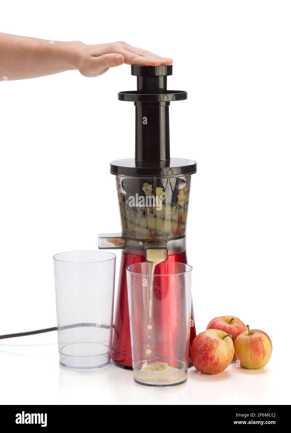 juicer making juice, with a hand on a white background Stock Photo - Alamy