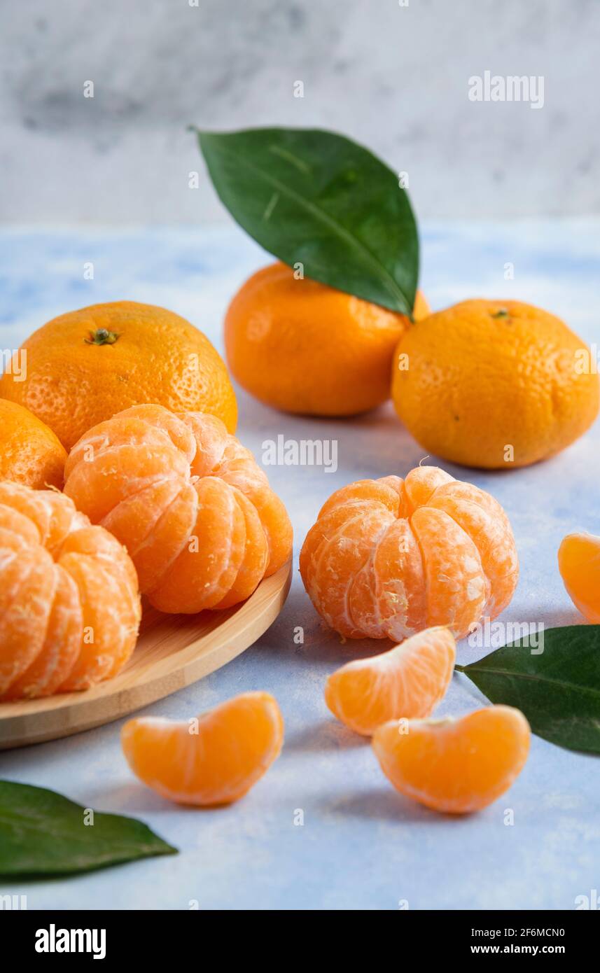 Vertical photo of peeled and whole mandarins Stock Photo - Alamy