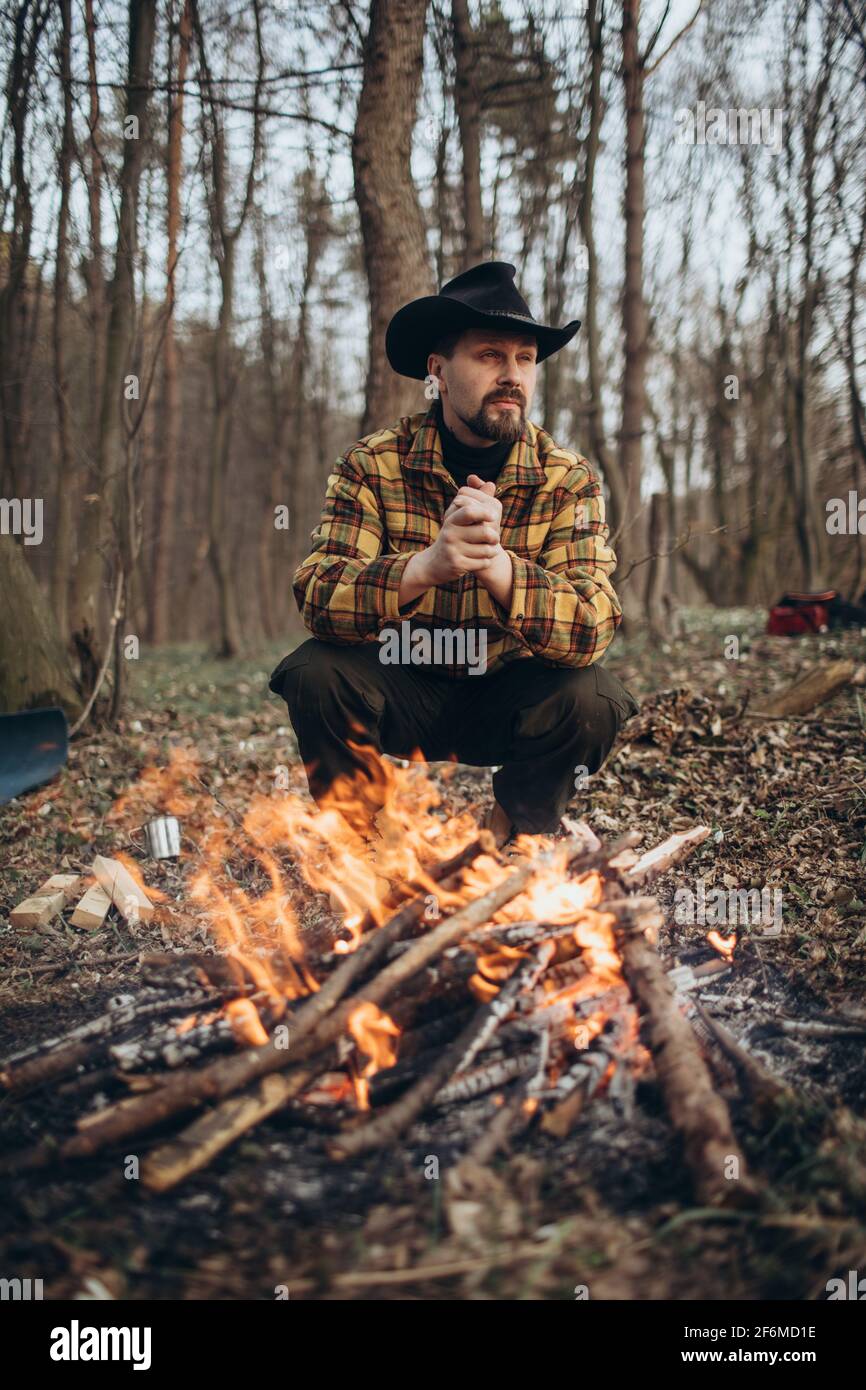 Man sitting near bonfire Stock Photo - Alamy