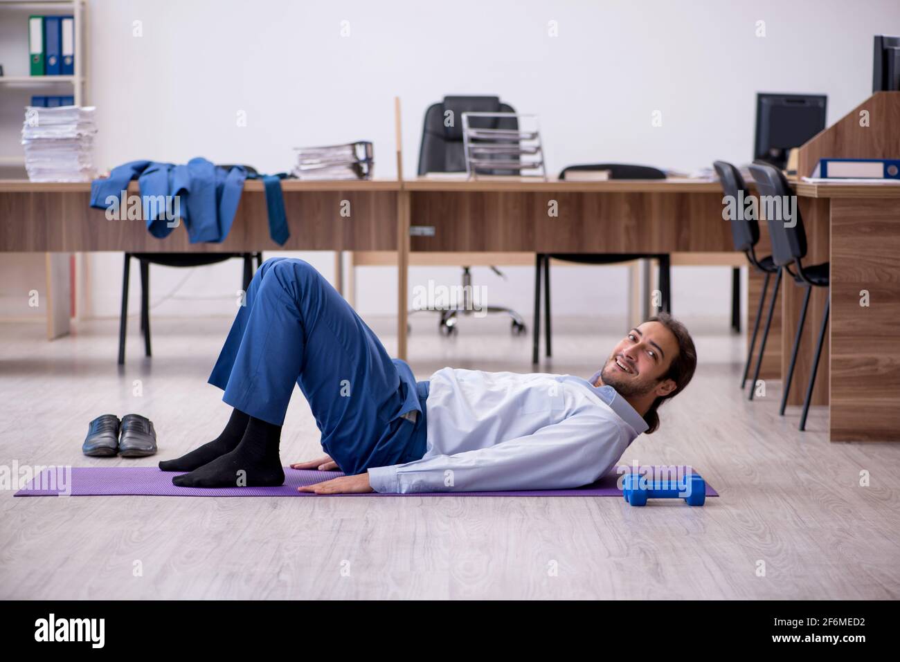 Young employee doing sport exercises during break Stock Photo - Alamy