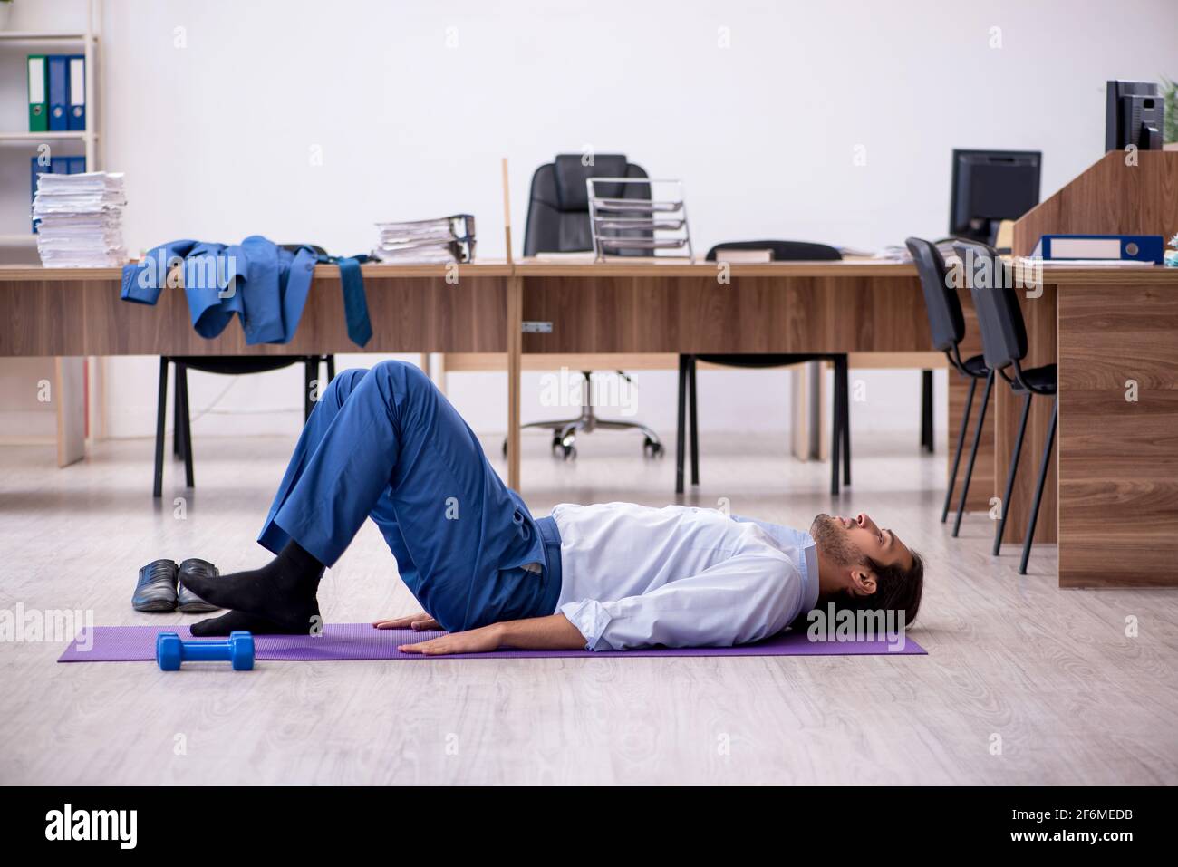 Young employee doing sport exercises during break Stock Photo - Alamy