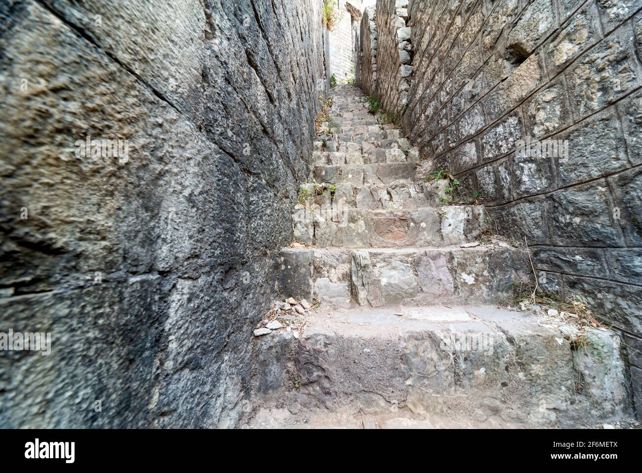 Steep crumbling steps between ancient historic 16th century walls of ...