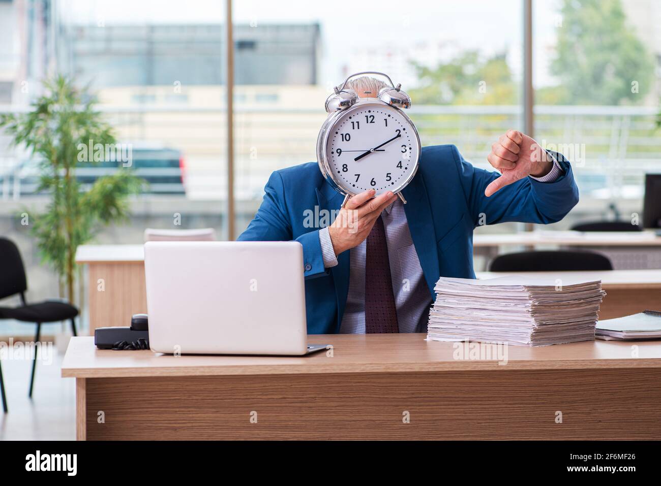 Old boss employee in time management concept Stock Photo - Alamy