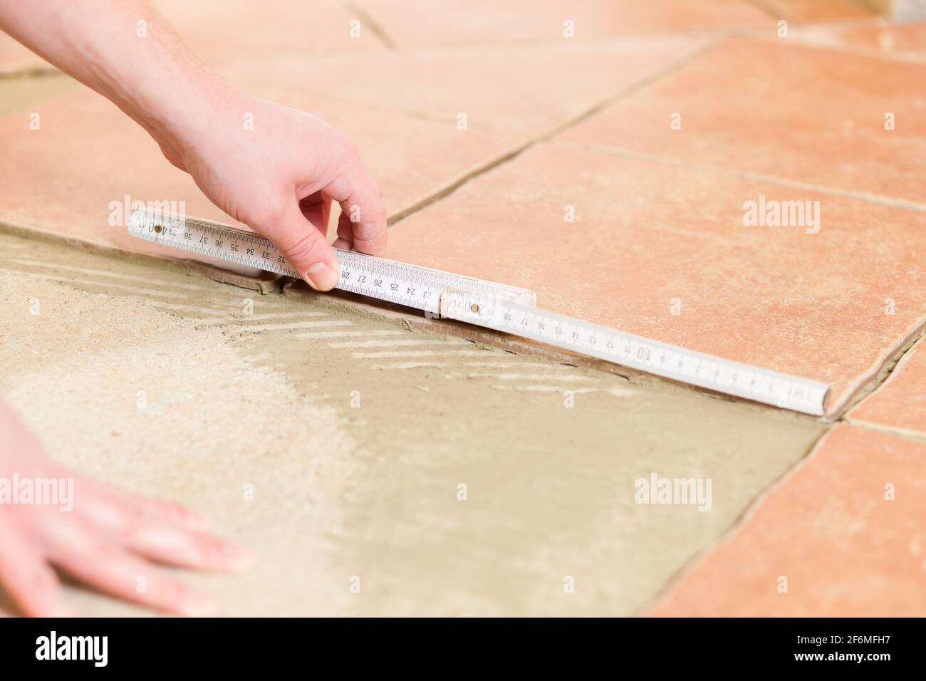 Construction worker is tiling at home Stock Photo - Alamy