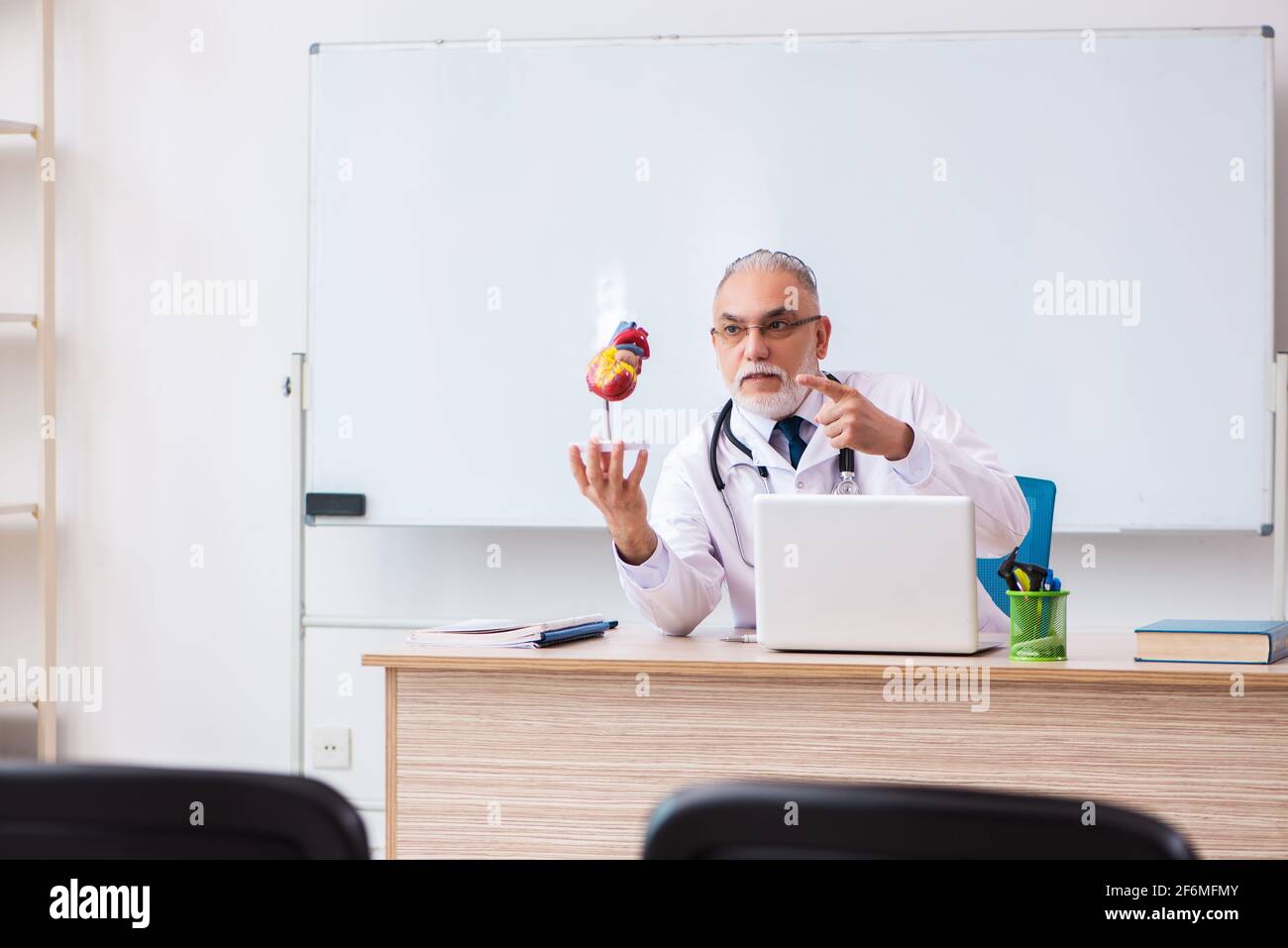 Old doctor lecturer in the classroom during pandemic Stock Photo - Alamy