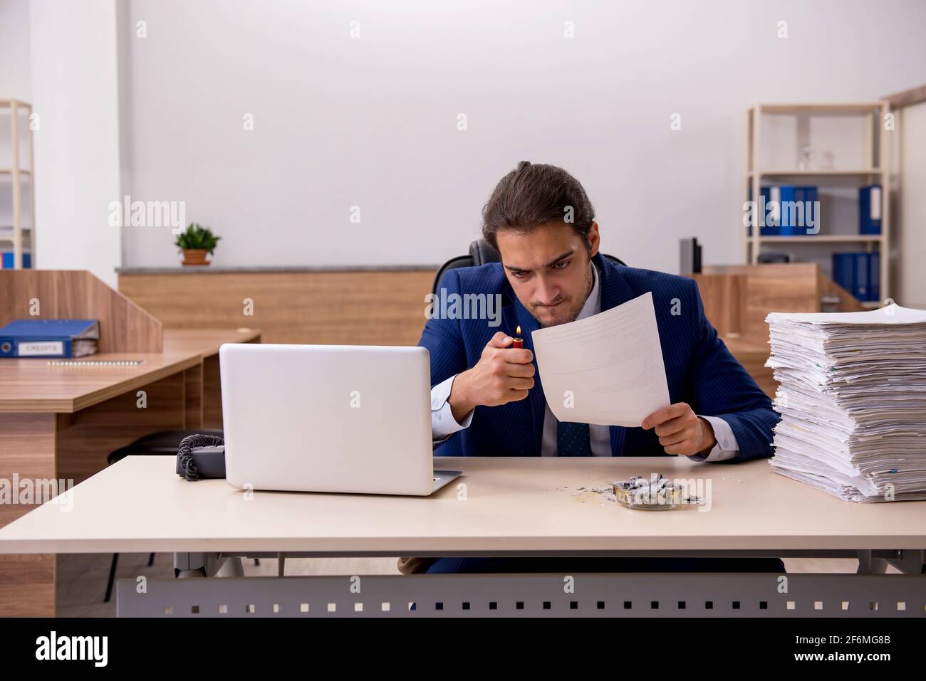 Young man employee burning papers in the office Stock Photo - Alamy