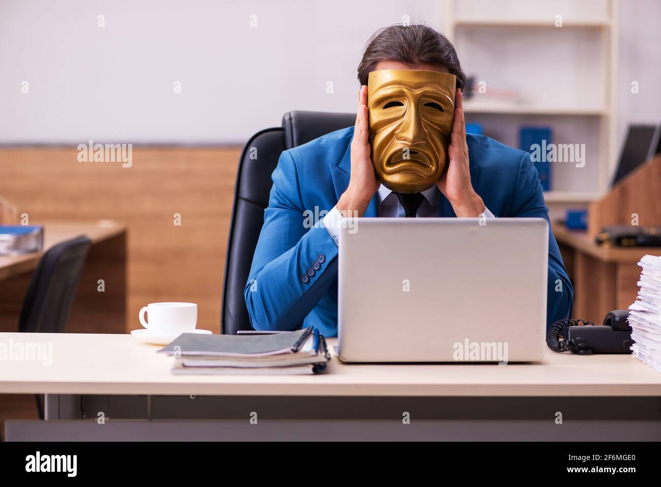 Young employee wearing sad mask in the office Stock Photo - Alamy