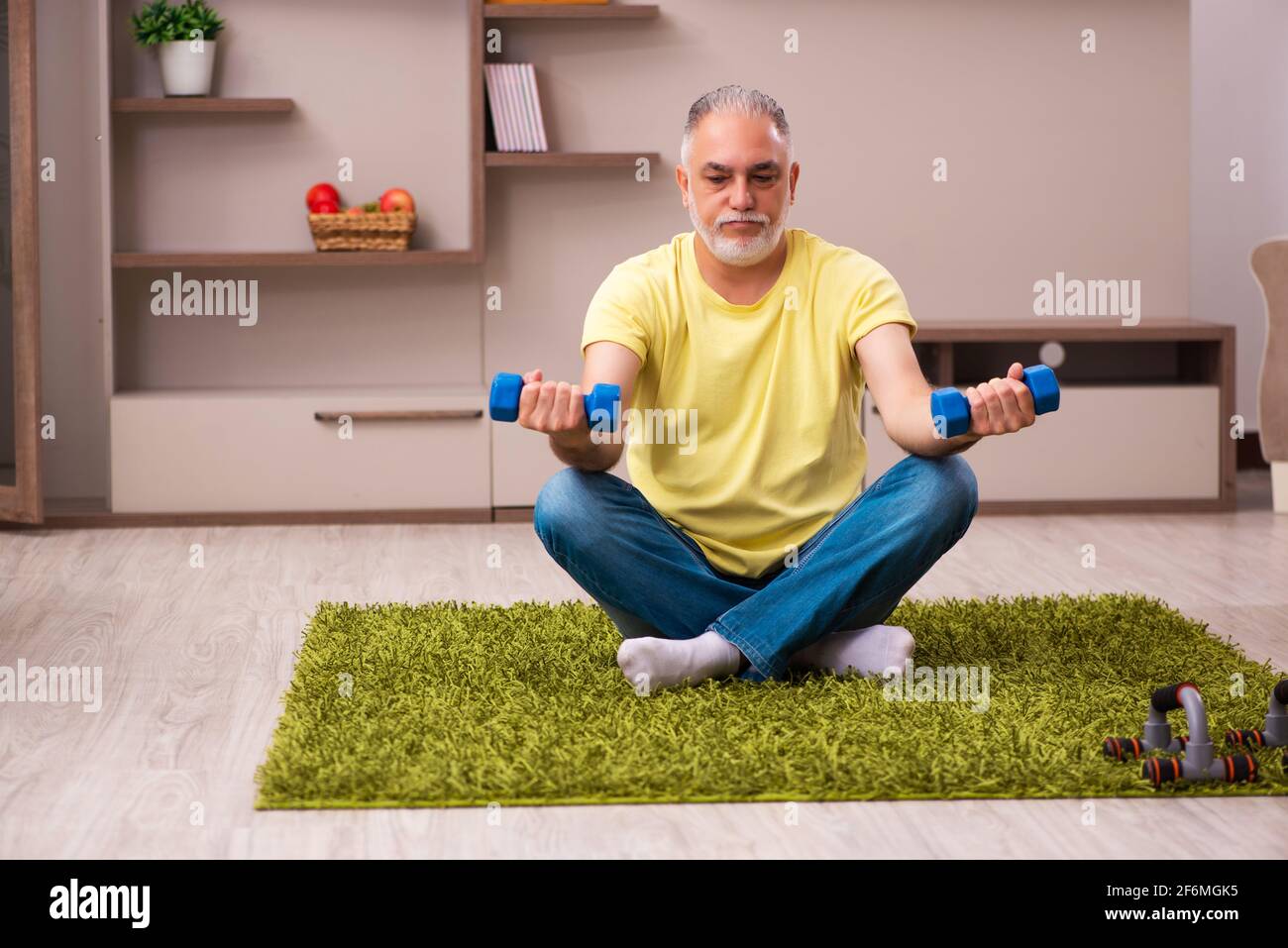 Old man doing sport exercises at home Stock Photo - Alamy
