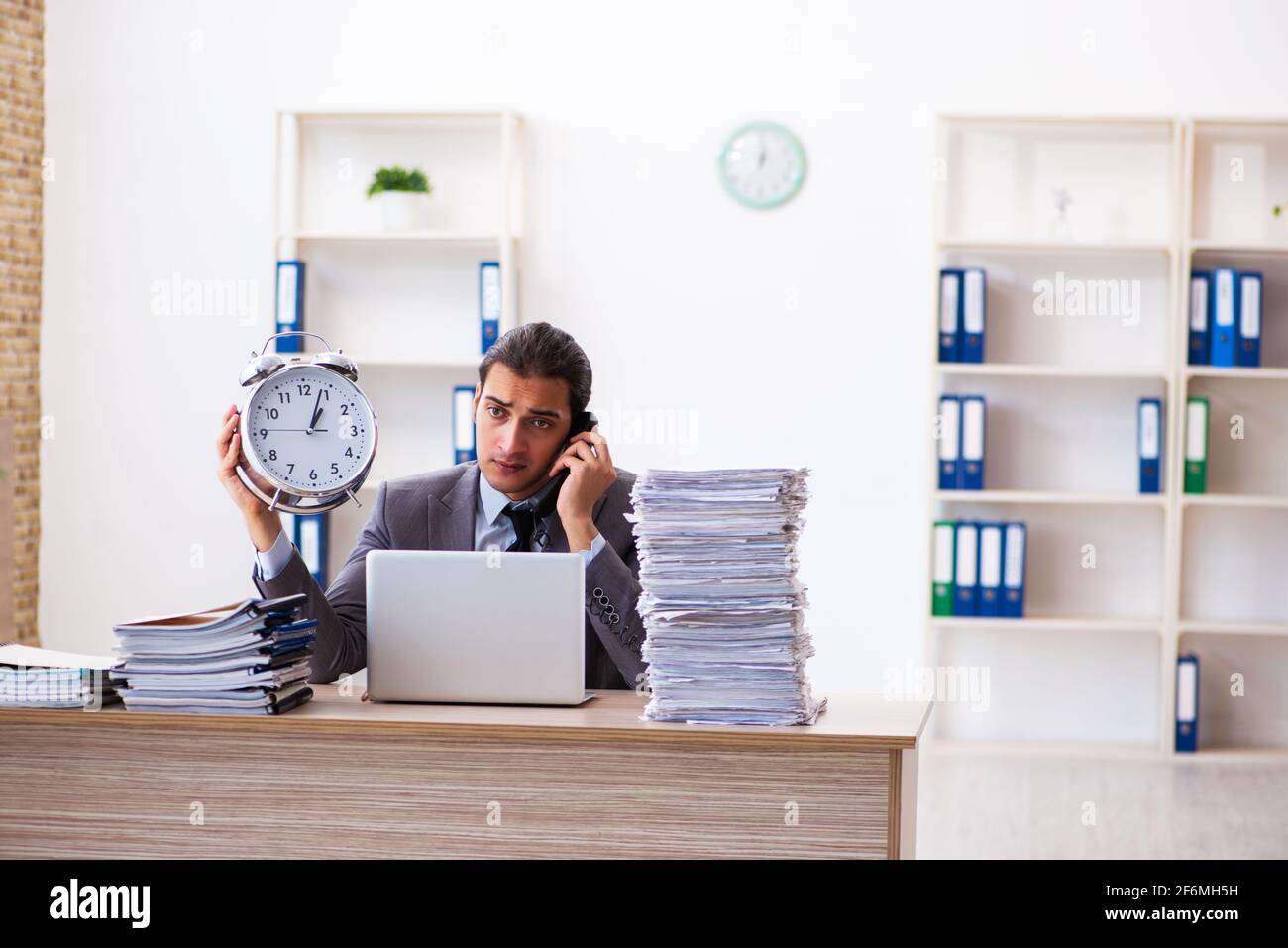 Workload employee in time management concept Stock Photo - Alamy