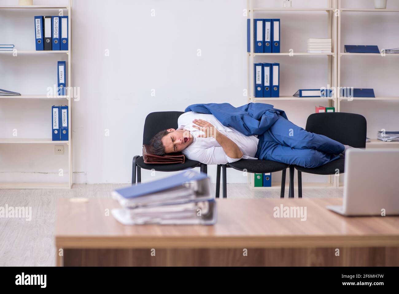 Young employee sleeping in the office on chairs Stock Photo - Alamy
