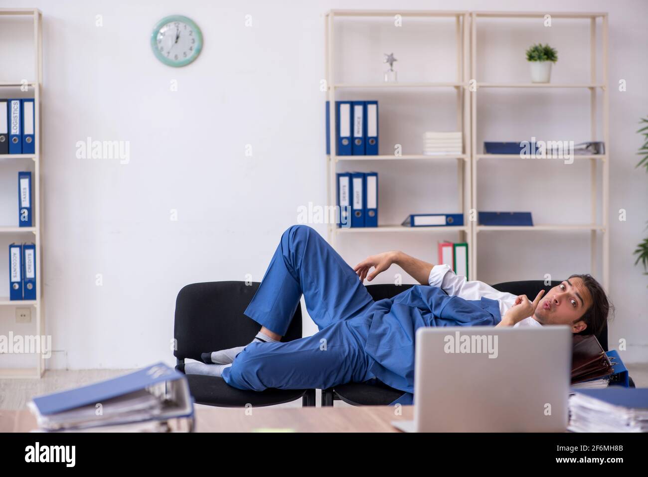 Young employee sleeping in the office on chairs Stock Photo - Alamy