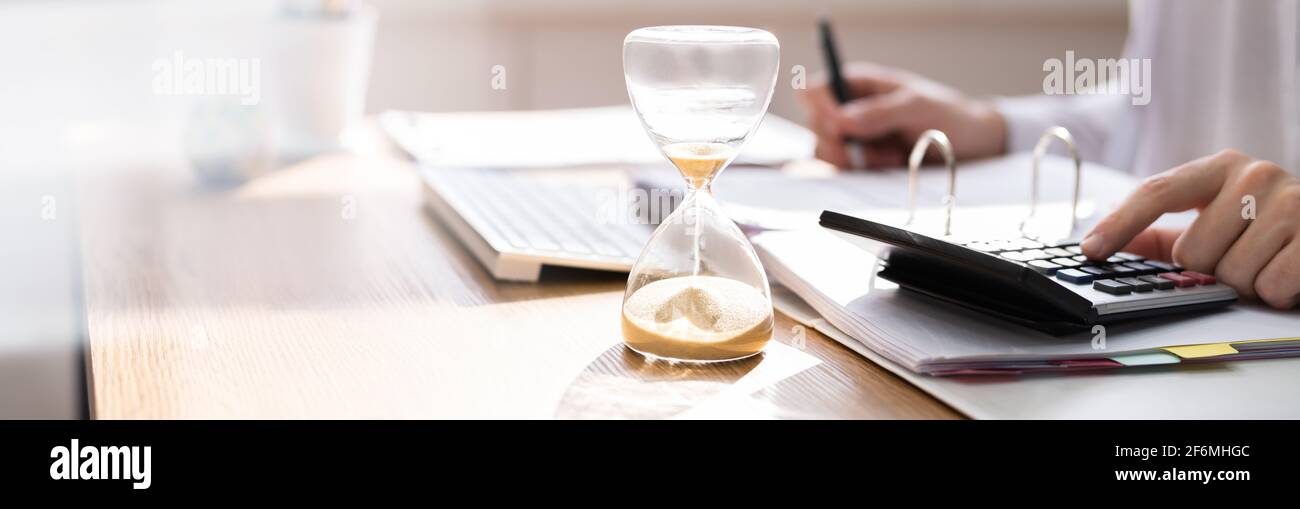 Accountant Calculating Invoice Bill In Time With Hourglass Stock Photo ...