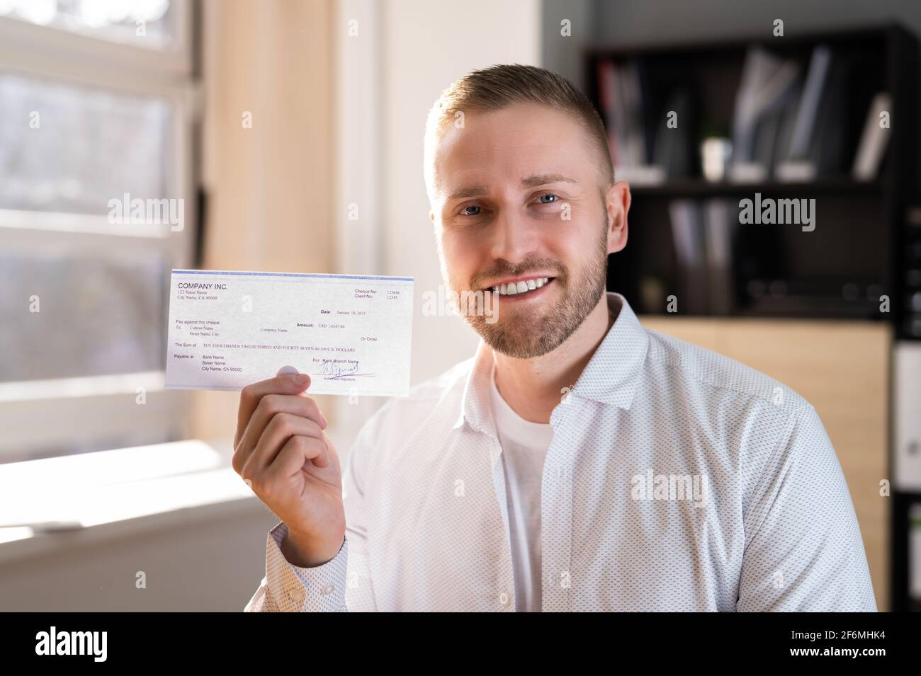 Holding Paycheck In Hand. Insurance And Payroll Check Stock Photo - Alamy