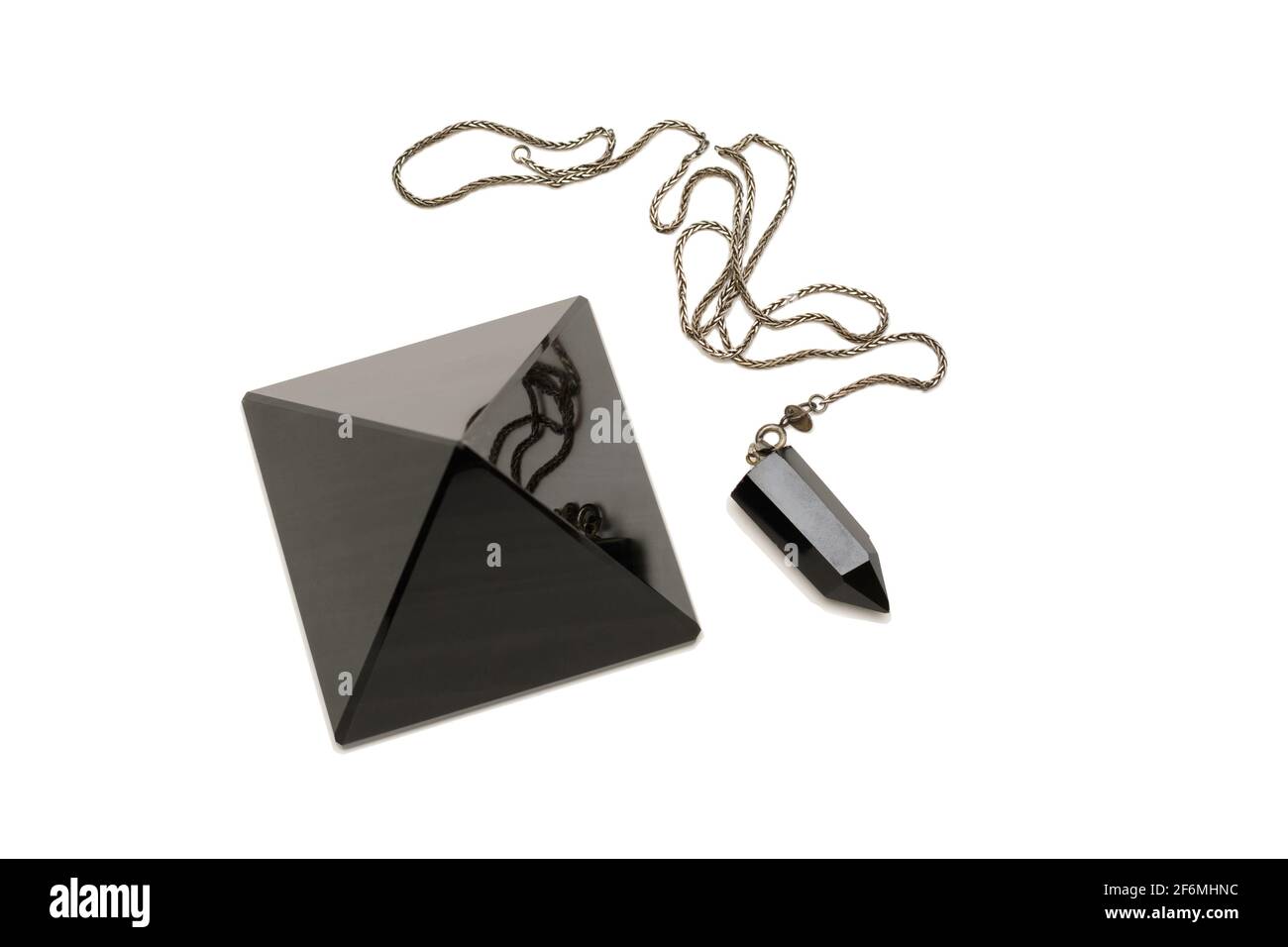 Items of magic from black onyx. Pyramid and pendulum. Isolated white ...