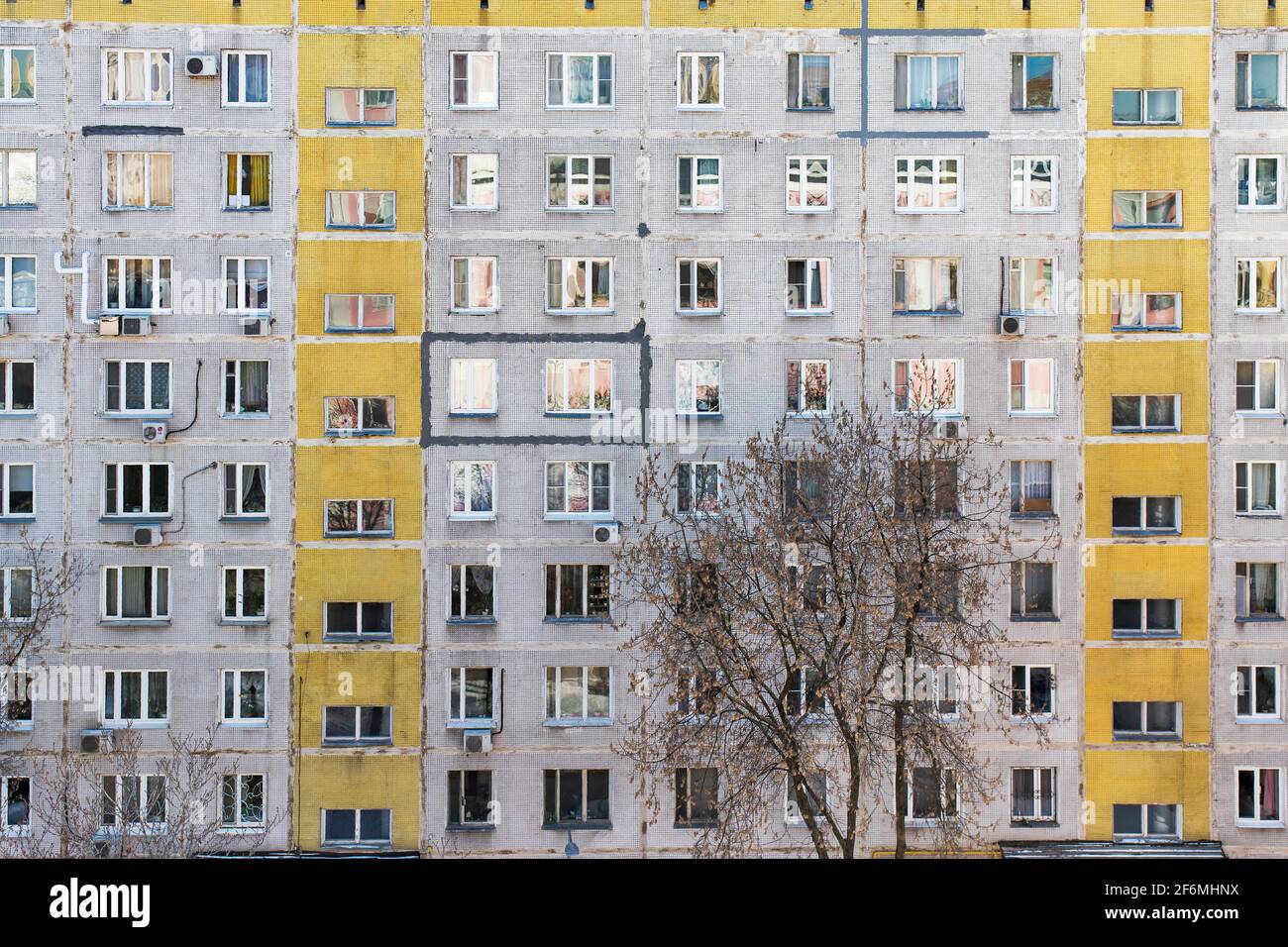 The facade of a nine-storey block house with yellow stripes. Moscow ...
