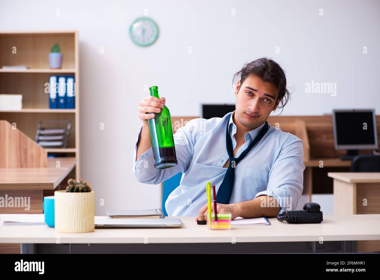 Male employee drinking alcohol at workplace Stock Photo - Alamy