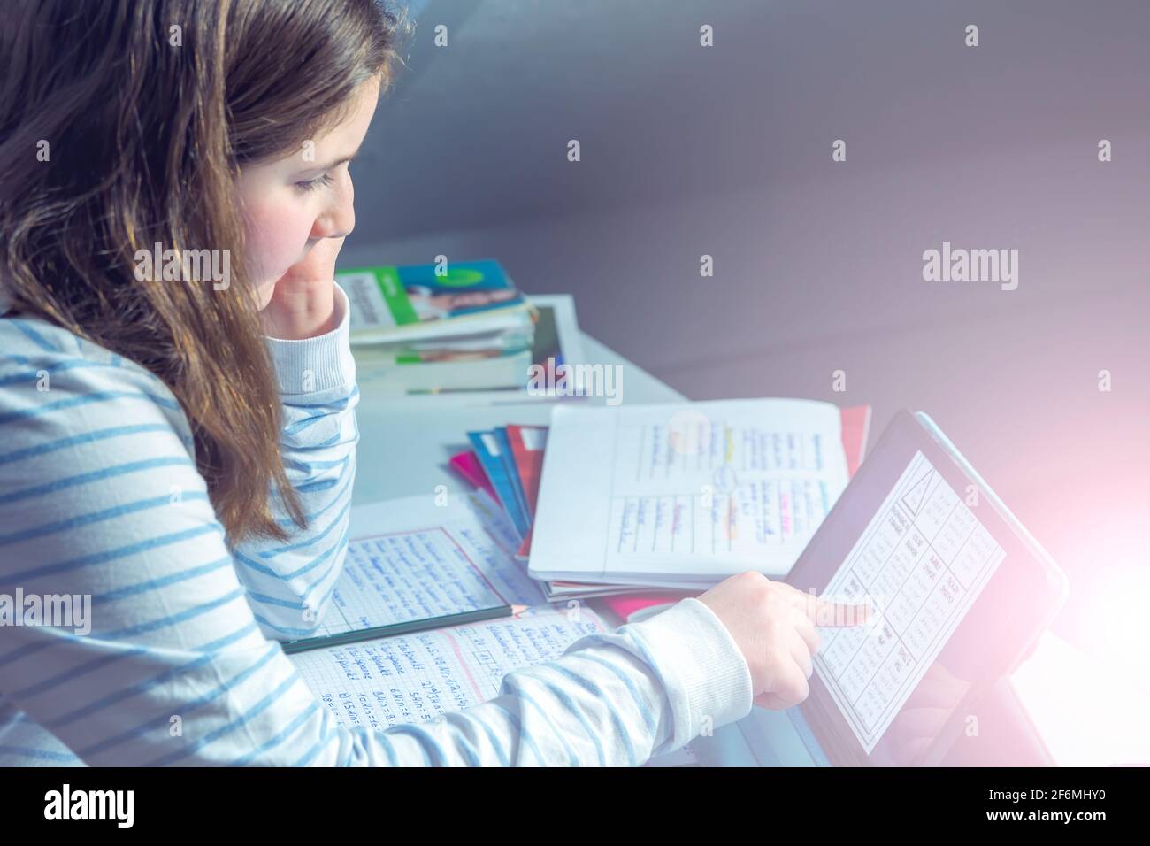 A girl studies at home using a tablet and communicates through the ...