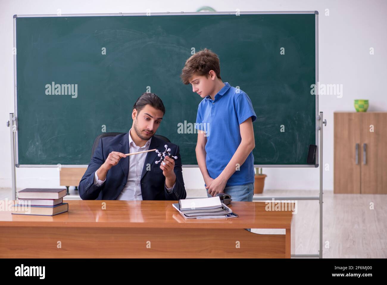 Male teacher and schoolboy in the classroom Stock Photo - Alamy