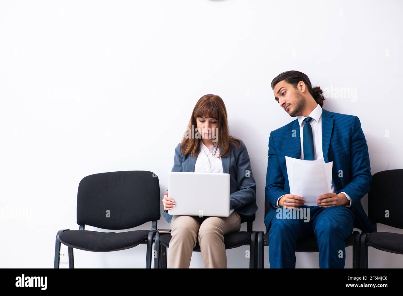 Businessman and businesswoman waiting for an interview at hall Stock ...