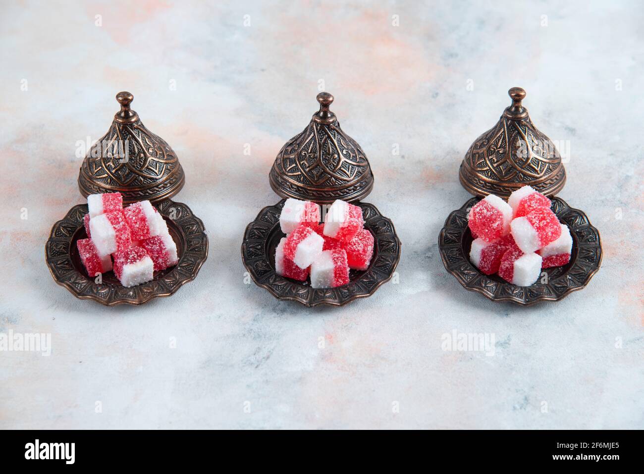 Candy crockery and pink candies in a row over white background Stock ...