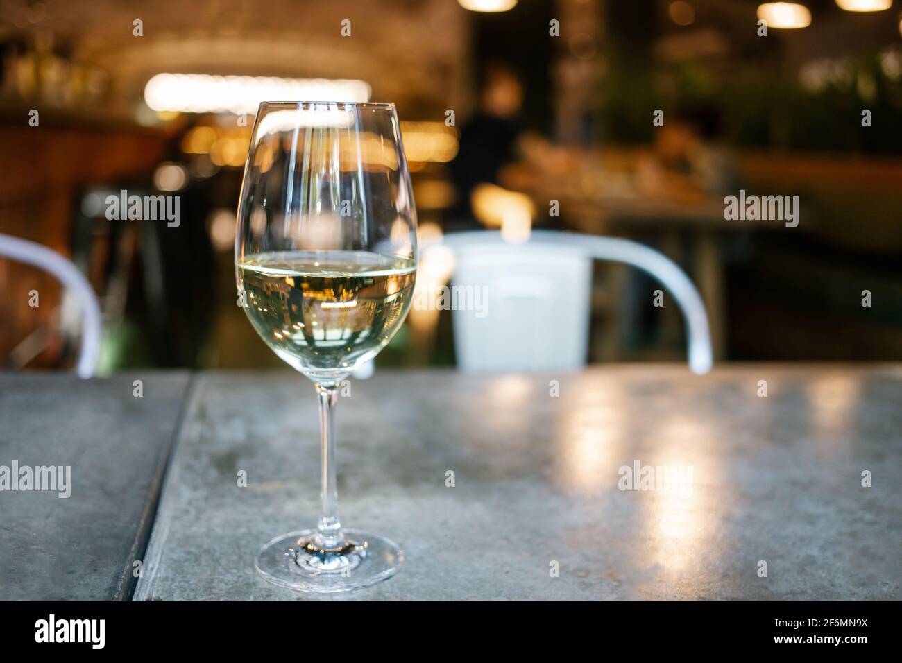 Glass of white wine on a table on a restaurant background Stock Photo ...