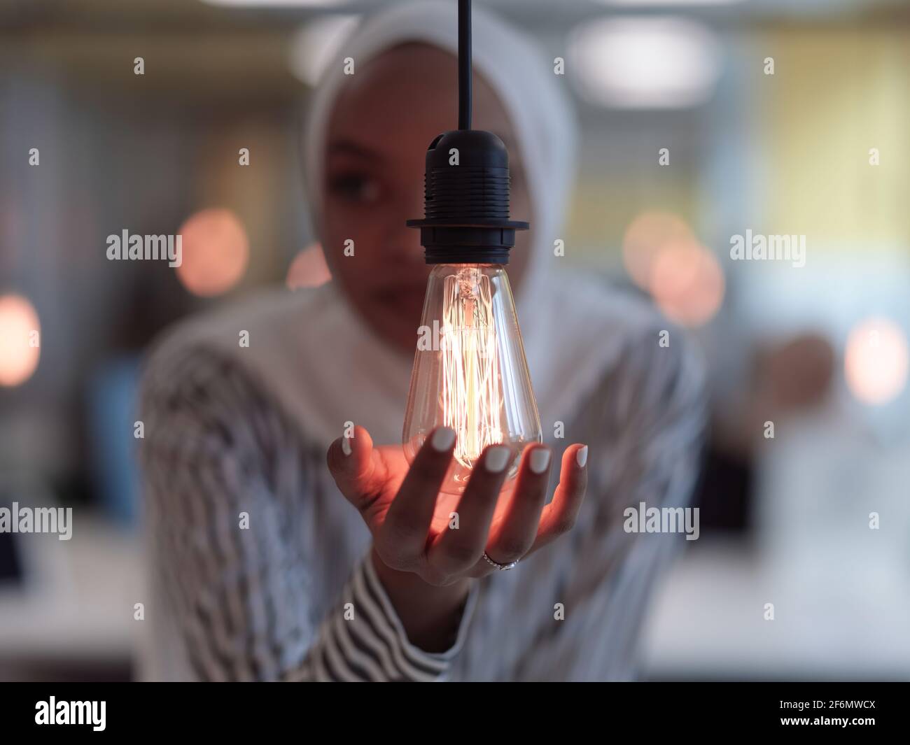 african american businesswoman holding hands around light bulb Stock ...