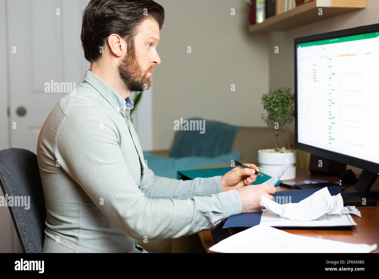 Man working from home on desktop computer with paperwork. HD 24FPS ...