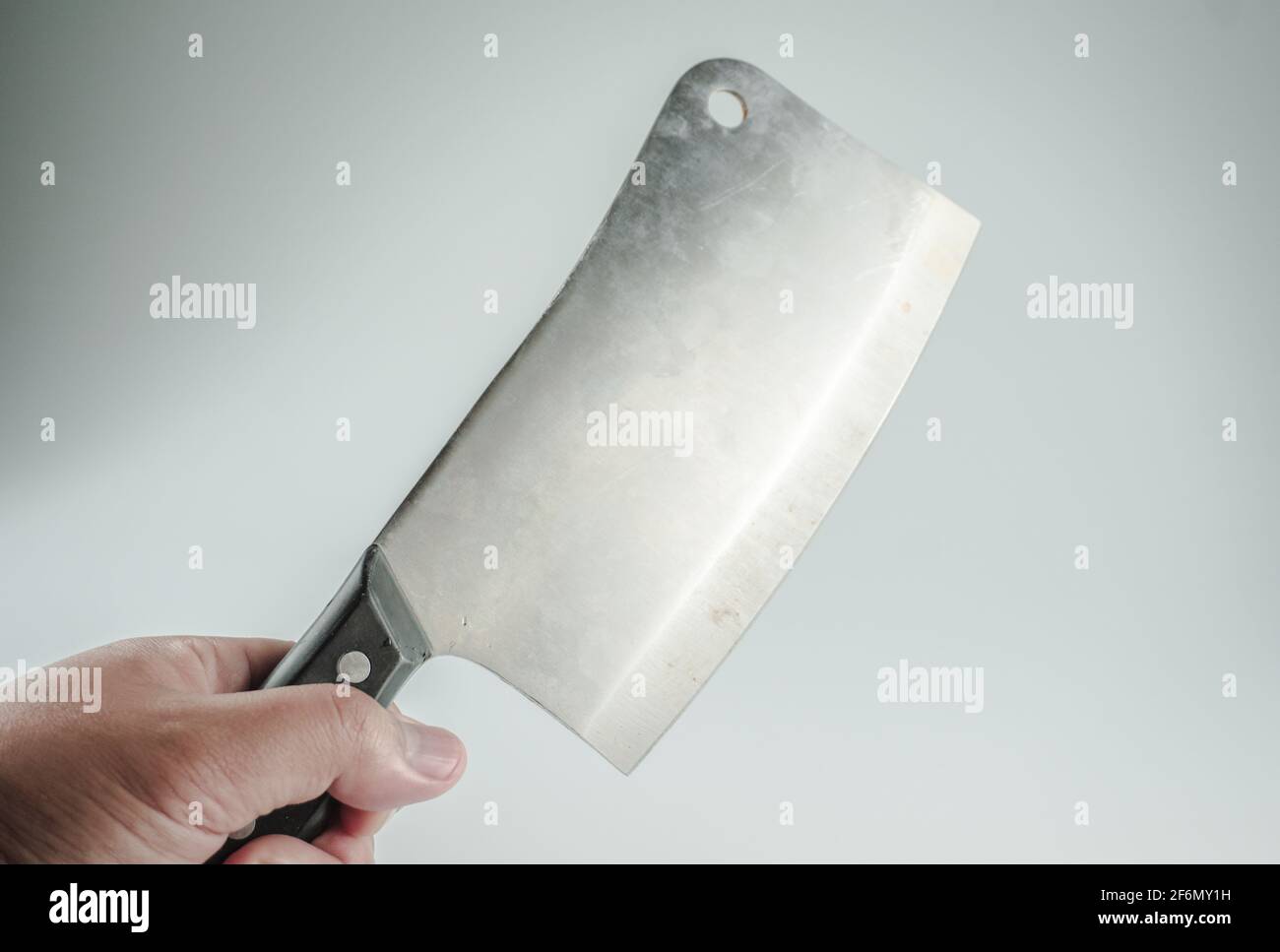 hand holding a butcher knife with white background. A butcher meat in ...