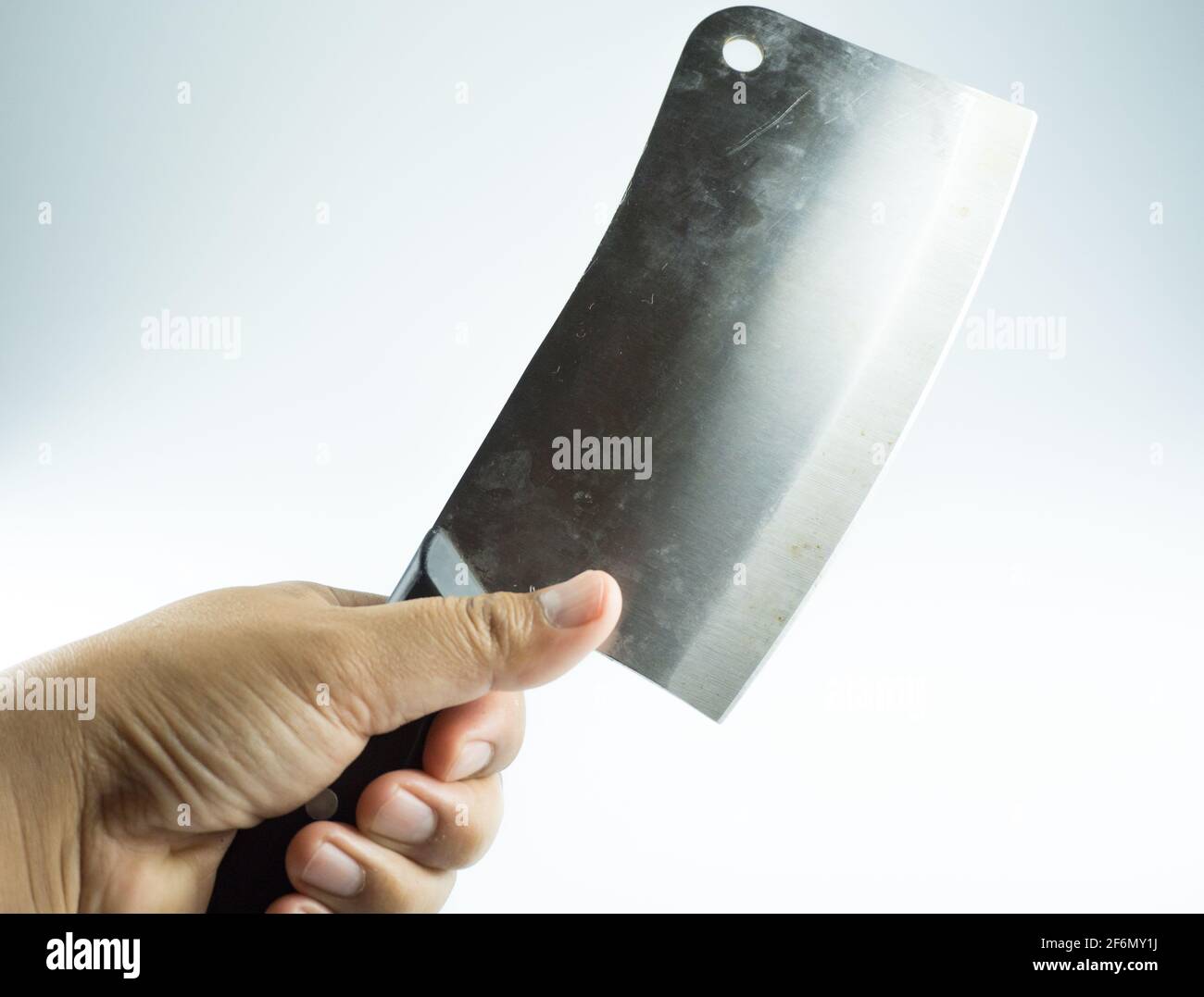 hand holding a butcher knife. A butcher meat in white background. an ...