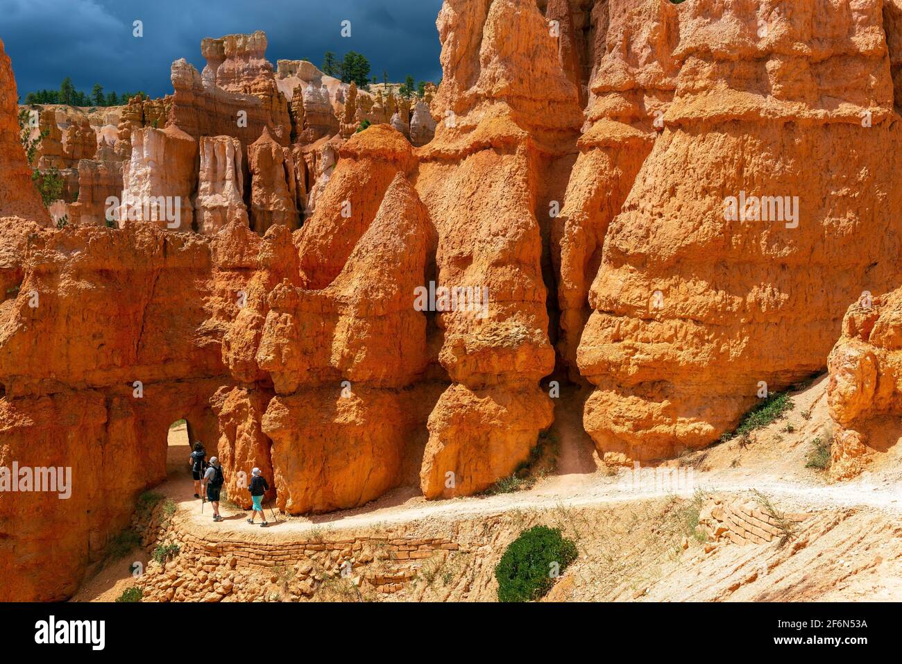 Tourists walking between Hoodoo rock formations along the Navajo Loop ...