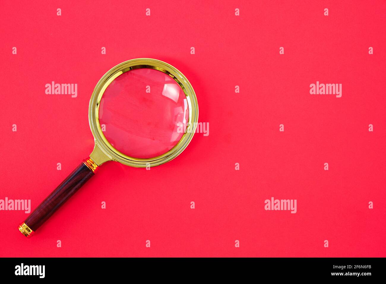 Magnifying glass on a bright red background Stock Photo - Alamy