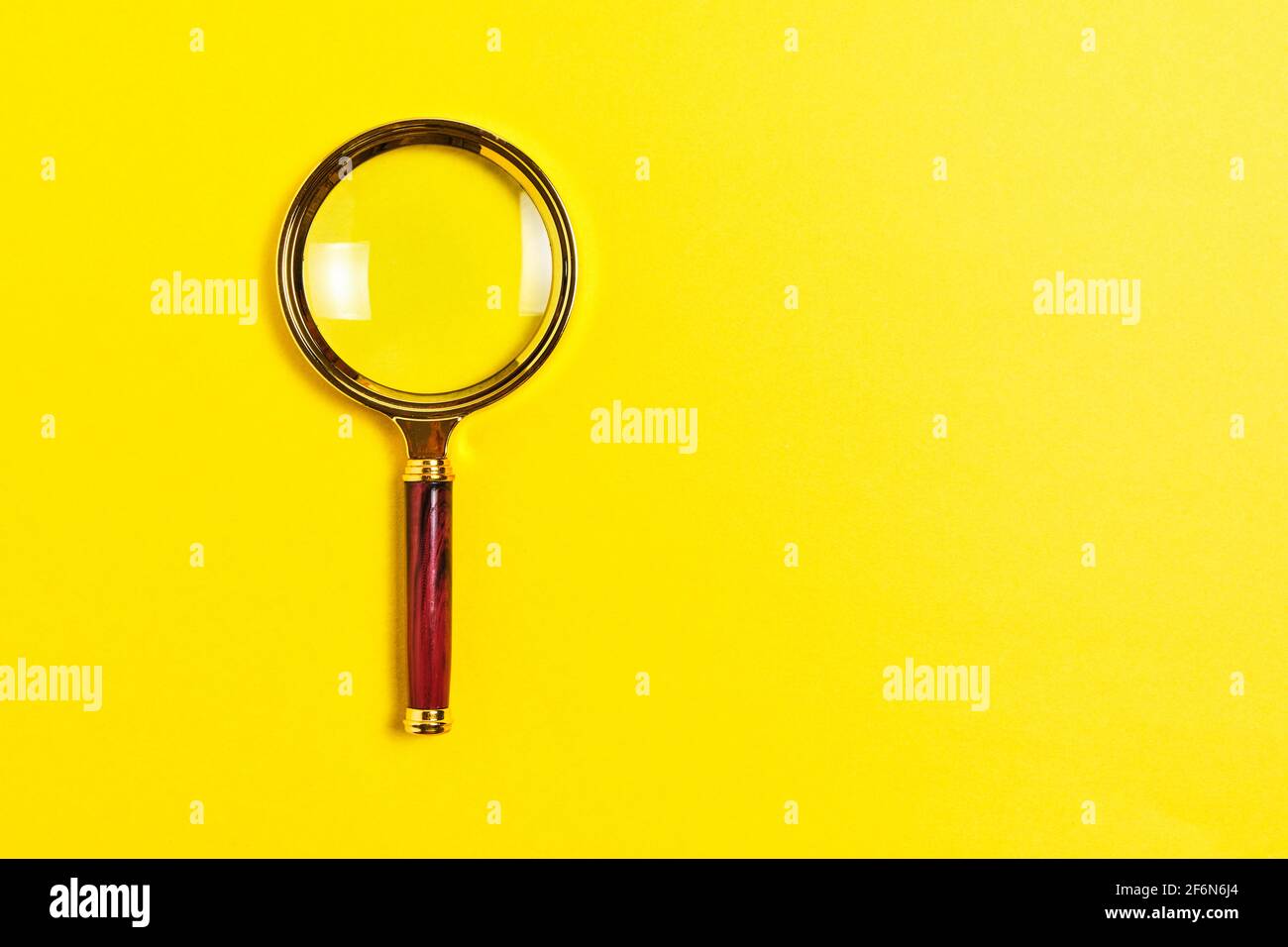 Magnifying glass on a bright yellow background Stock Photo - Alamy