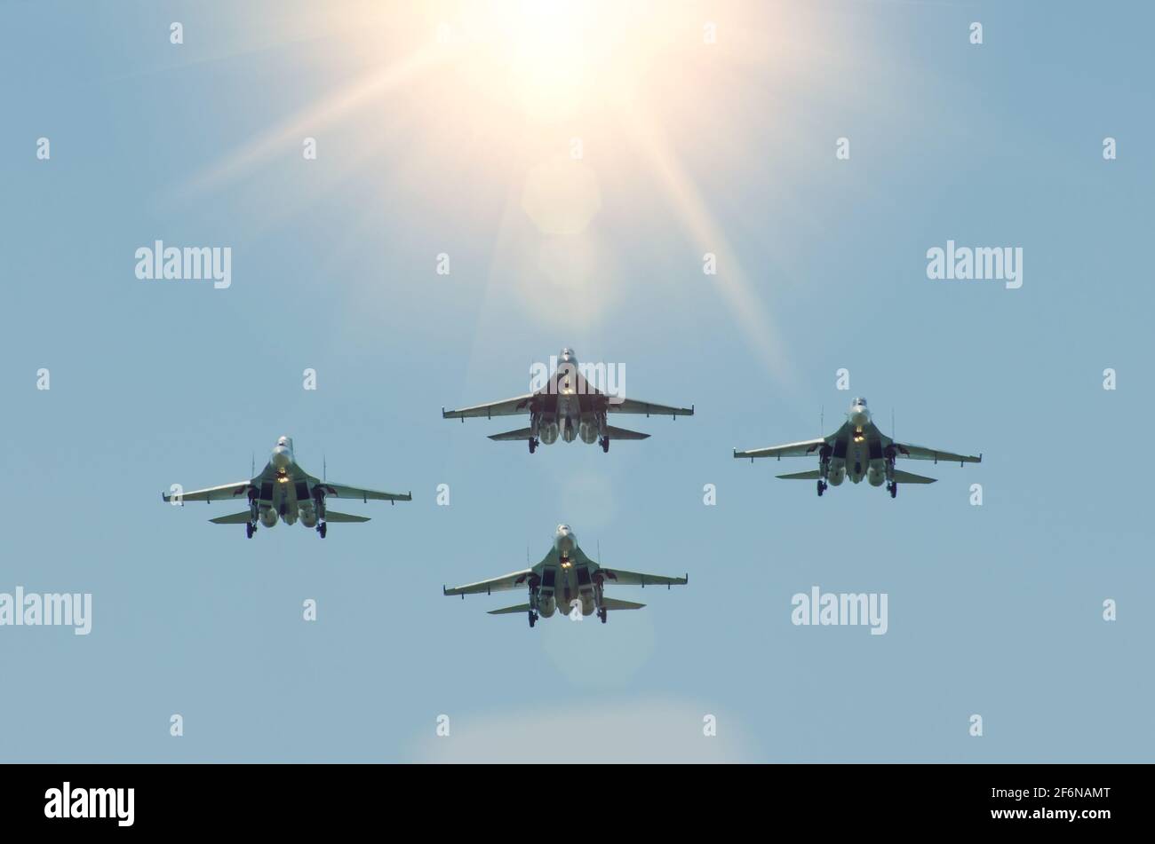 Formation of an aerobatic team against a blue sky with bright sunlight ...