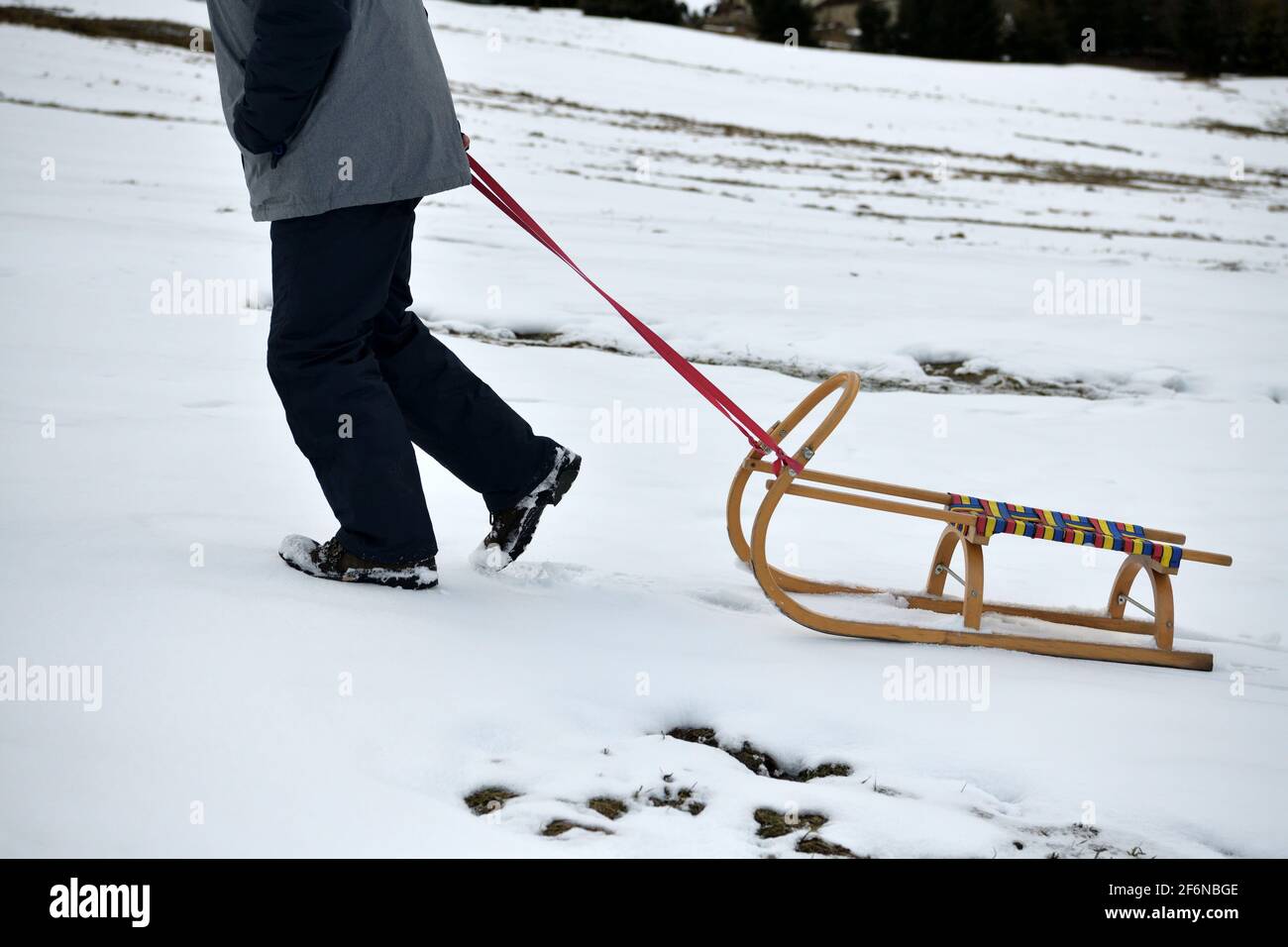 A man pulls a sledge up a hill in the winter tobogganing Stock Photo ...