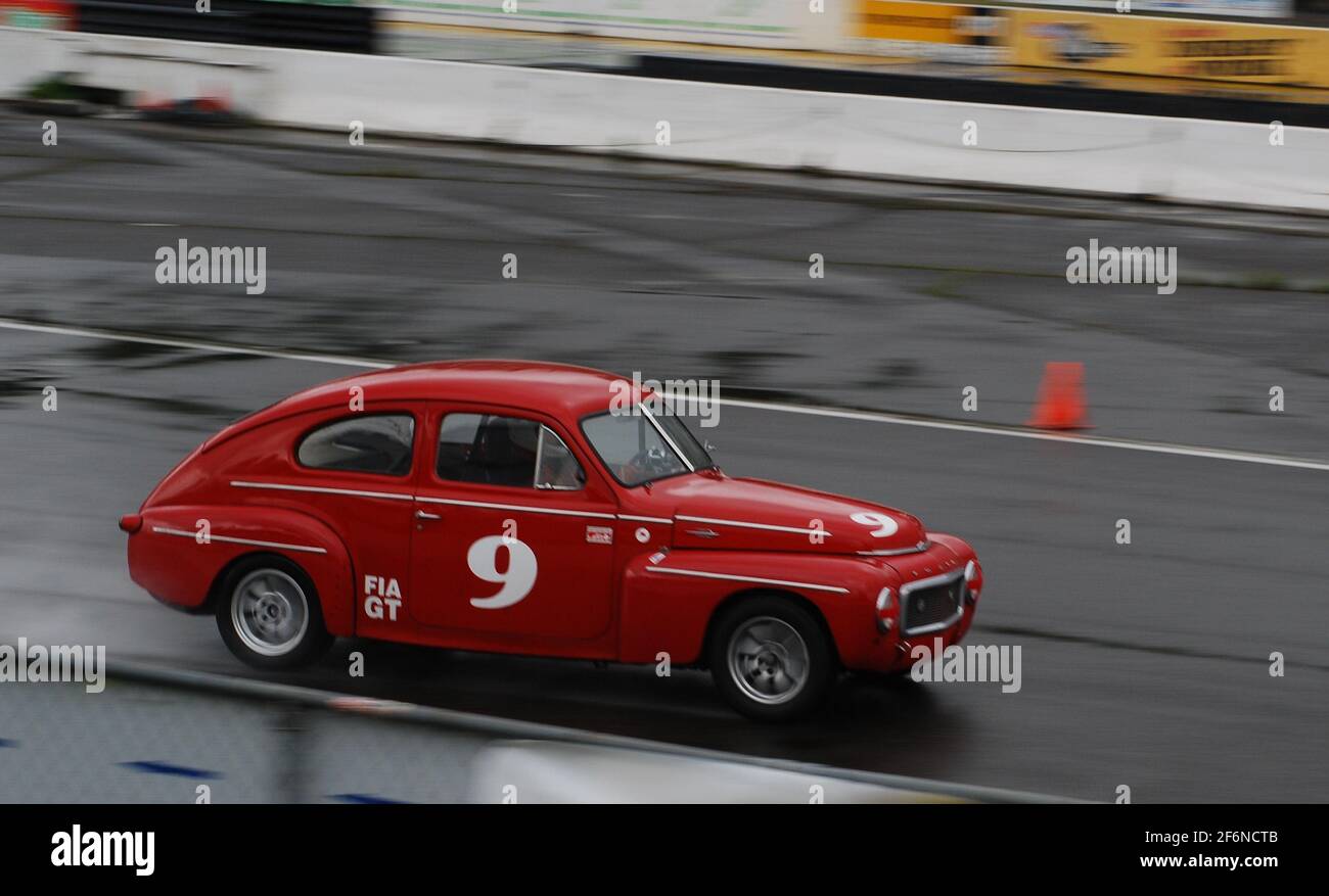 A 1958 Volvo PV444 speeds down the track at a vintage car race in the ...