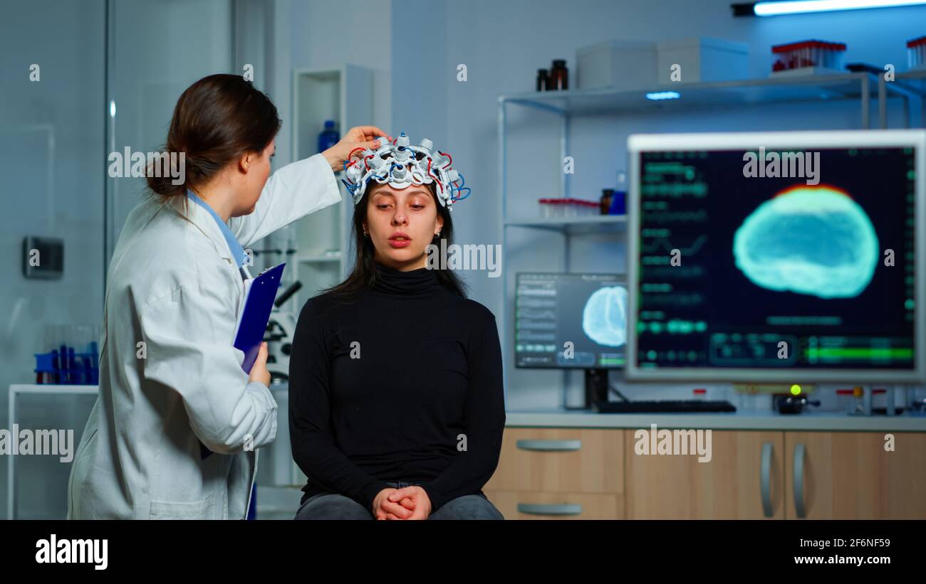 Neurological doctor cheking eeg headset explaining to patient diagnosis ...