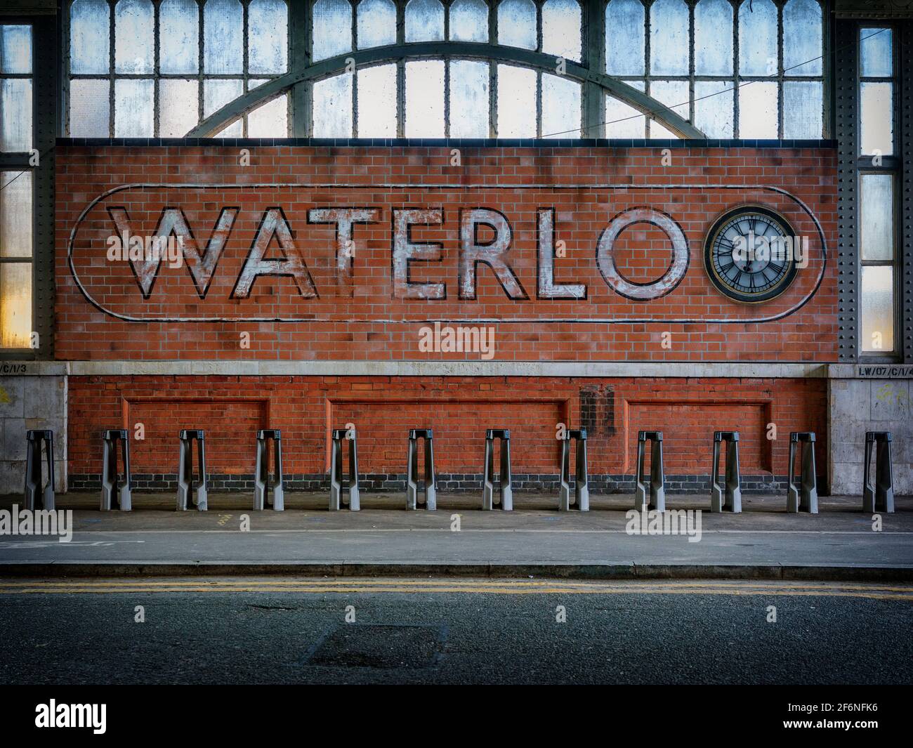 Waterloo Station sign on a brick wall incorporating a station clock ...