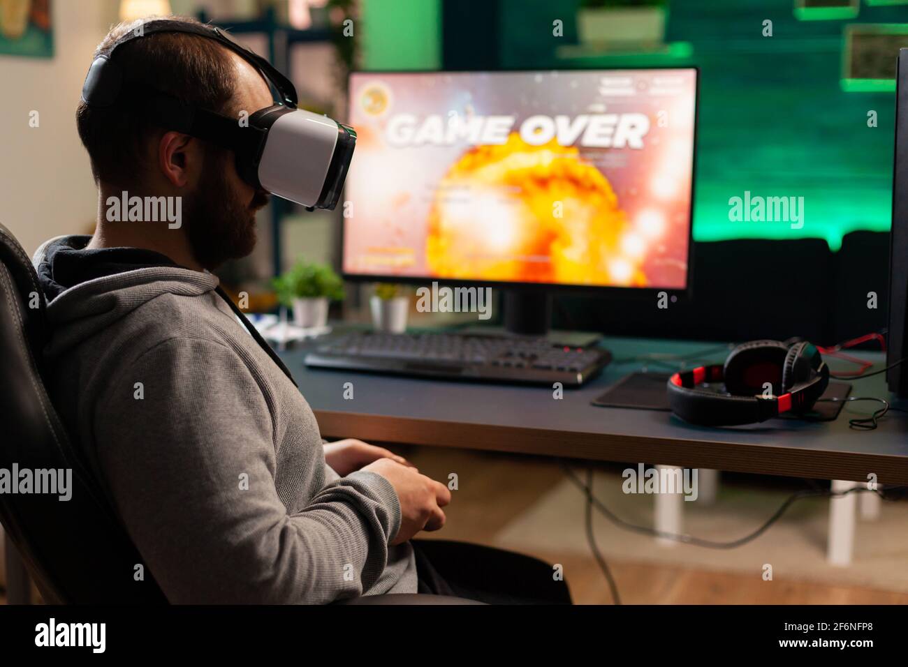 Videogame player losing space shooter competition while wearing virtual ...