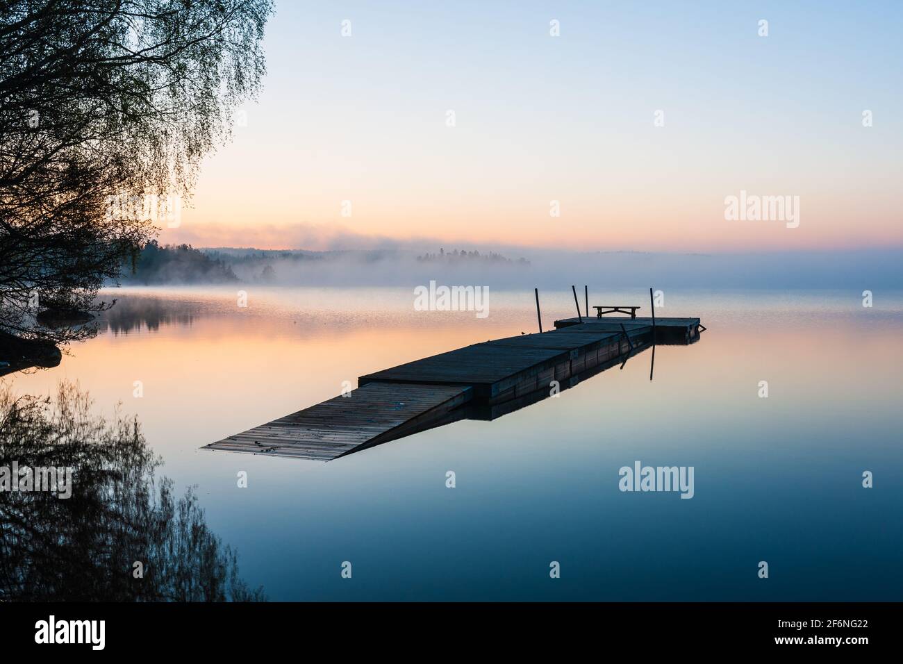 Wooden jetty floating on a calm and misty lake Stock Photo - Alamy