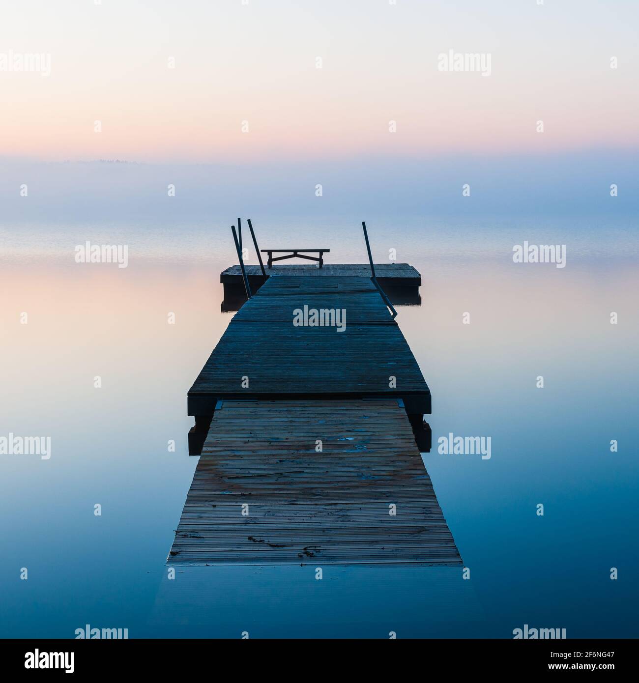 Wooden jetty floating on a calm and misty lake Stock Photo - Alamy