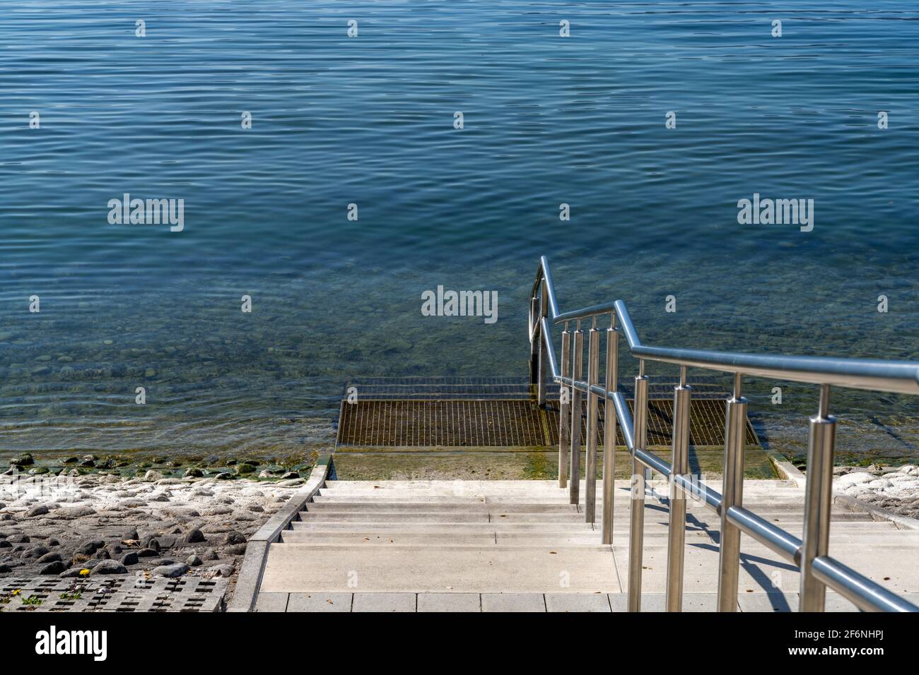 public bath area with stairs and railing leading into a calm blue lake ...