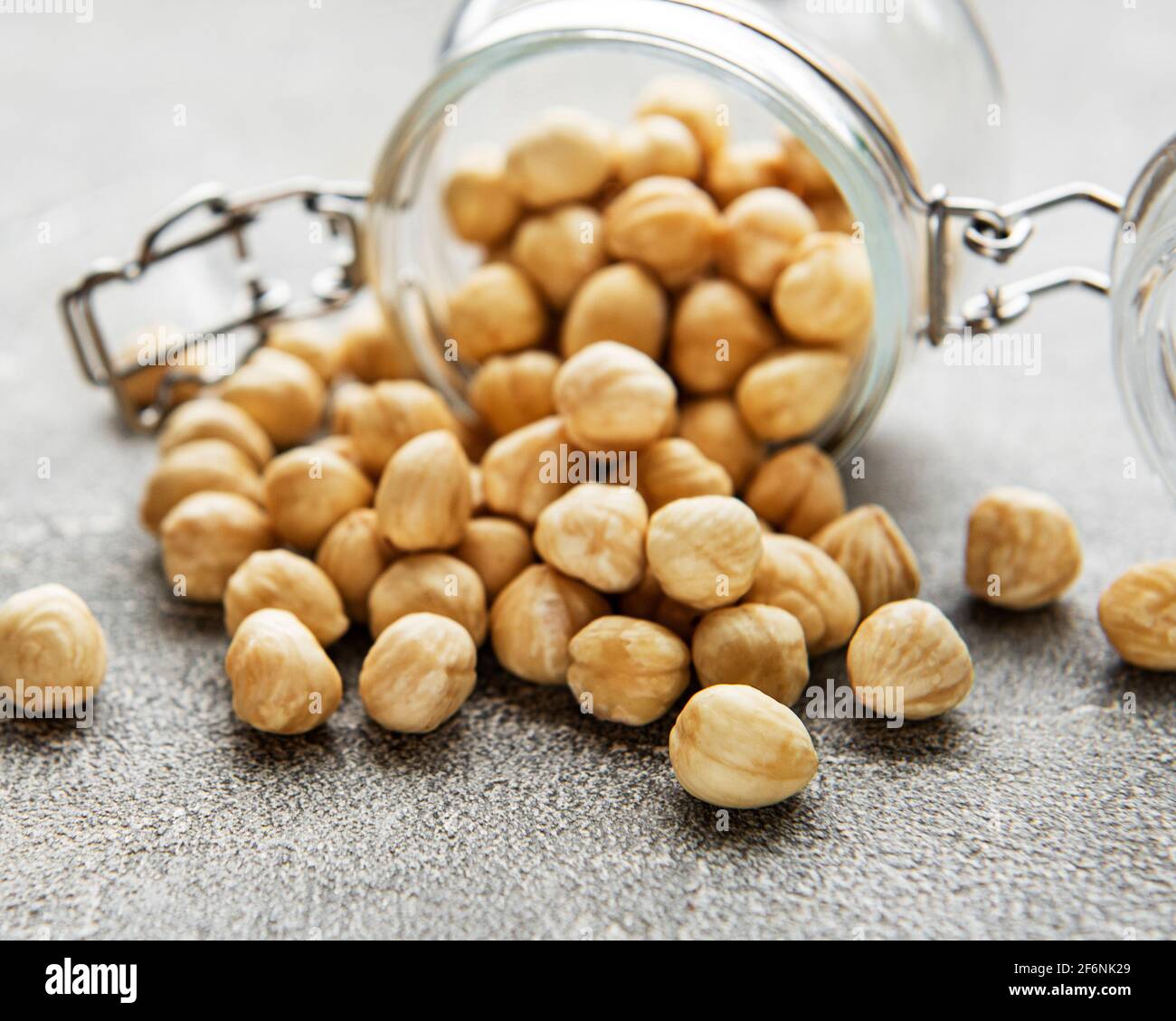 Peeled hazelnuts in a glass jar on grey concrete background Stock Photo ...