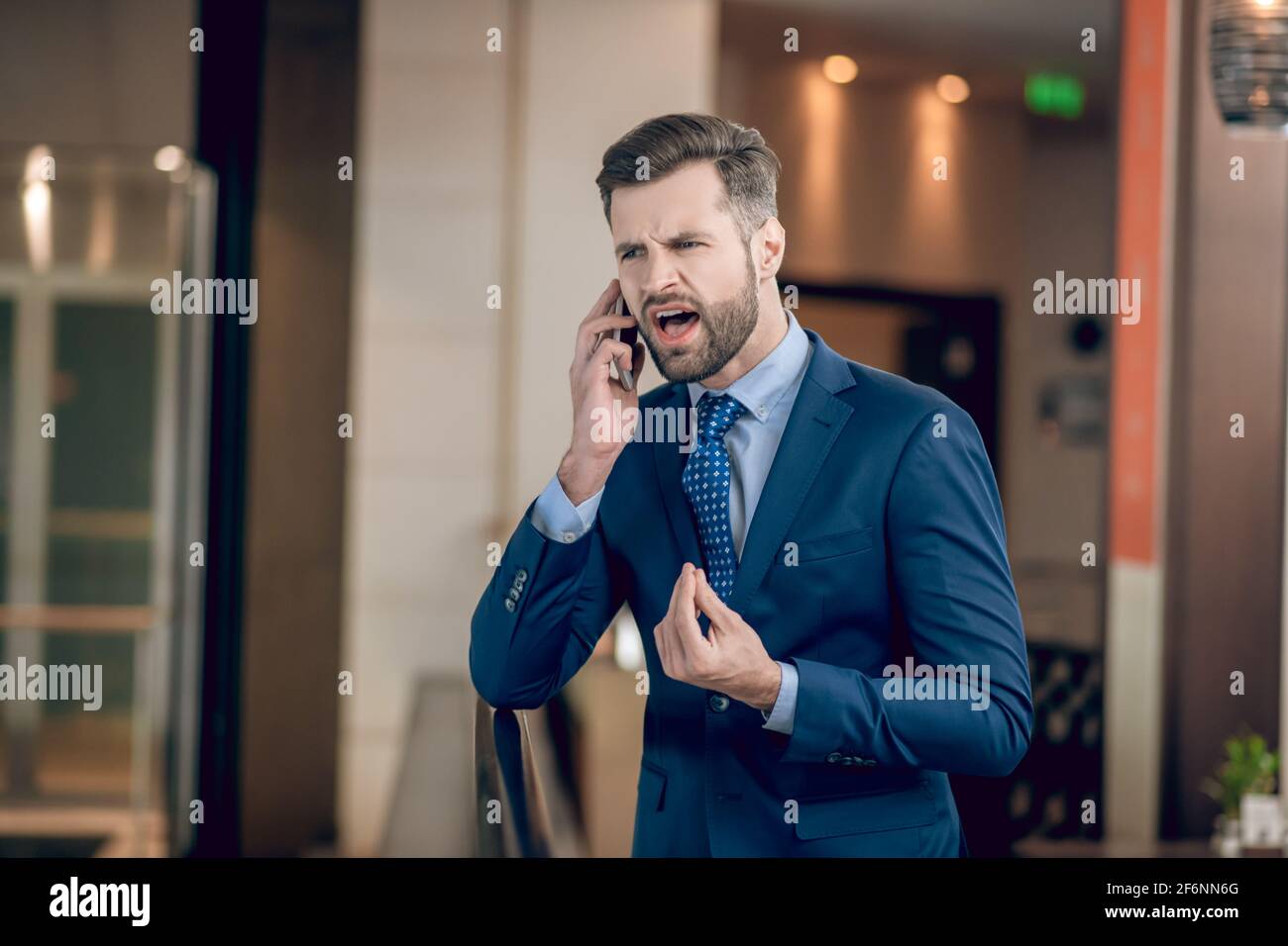 Problematic situation. Businessman in a blue suit talking on the phone ...